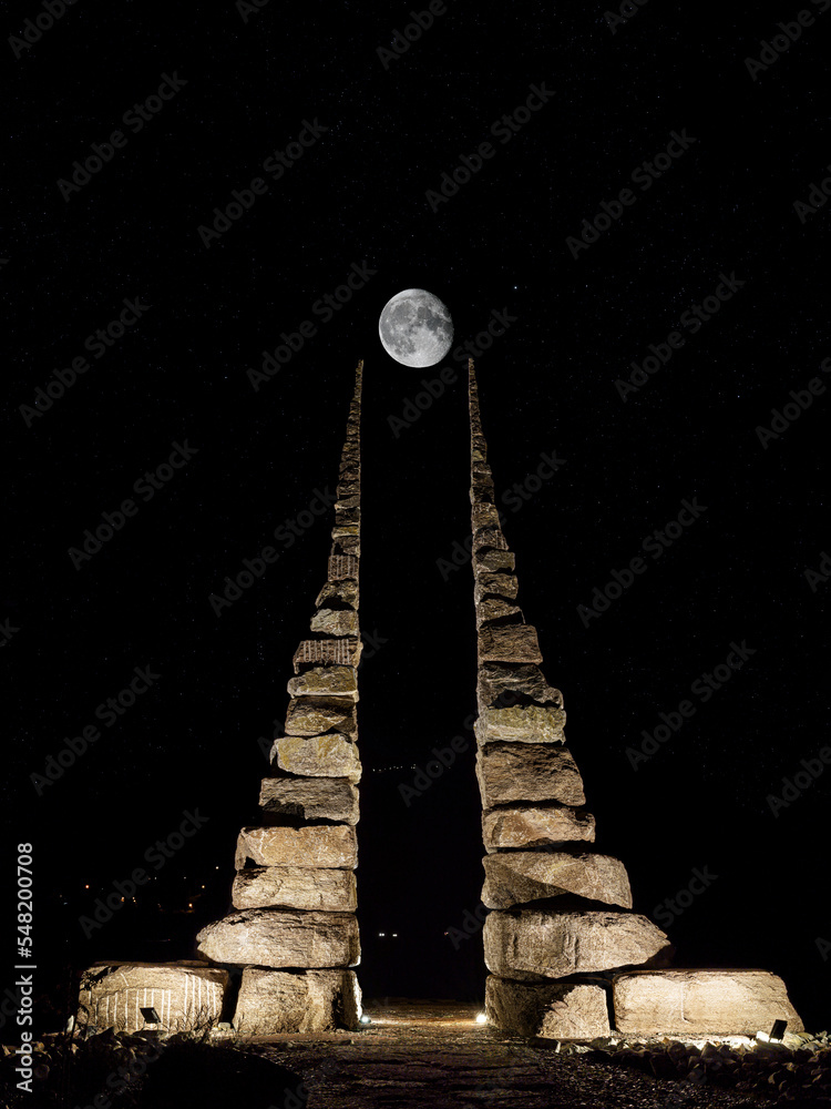 Artistic photo of two giant cairns, illuminated at night by spotlights ...