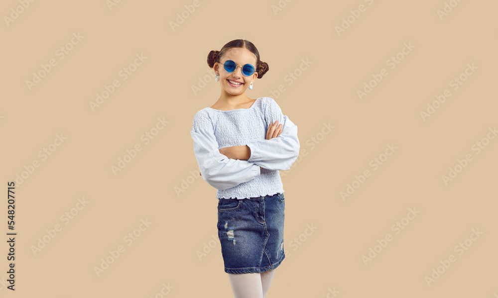 Happy adorable kid in fashion studio. Child model with space buns poses ...