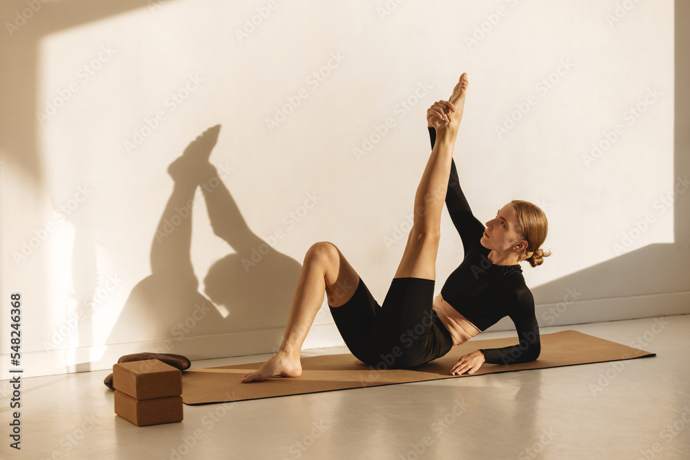Wellness exercise, woman on floor mat stretching alone, workout day ...