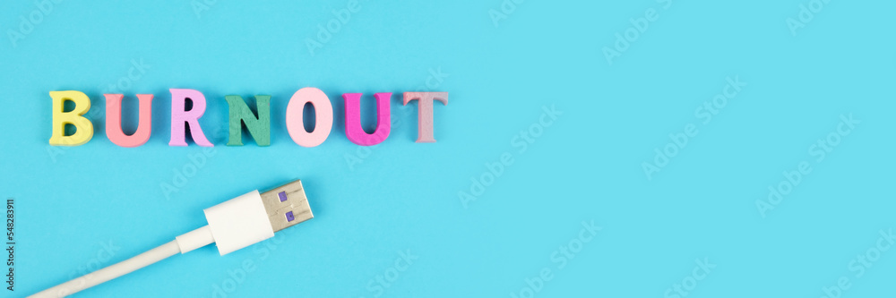 Word burnout from multi colored wooden letters and usb plug on blue ...