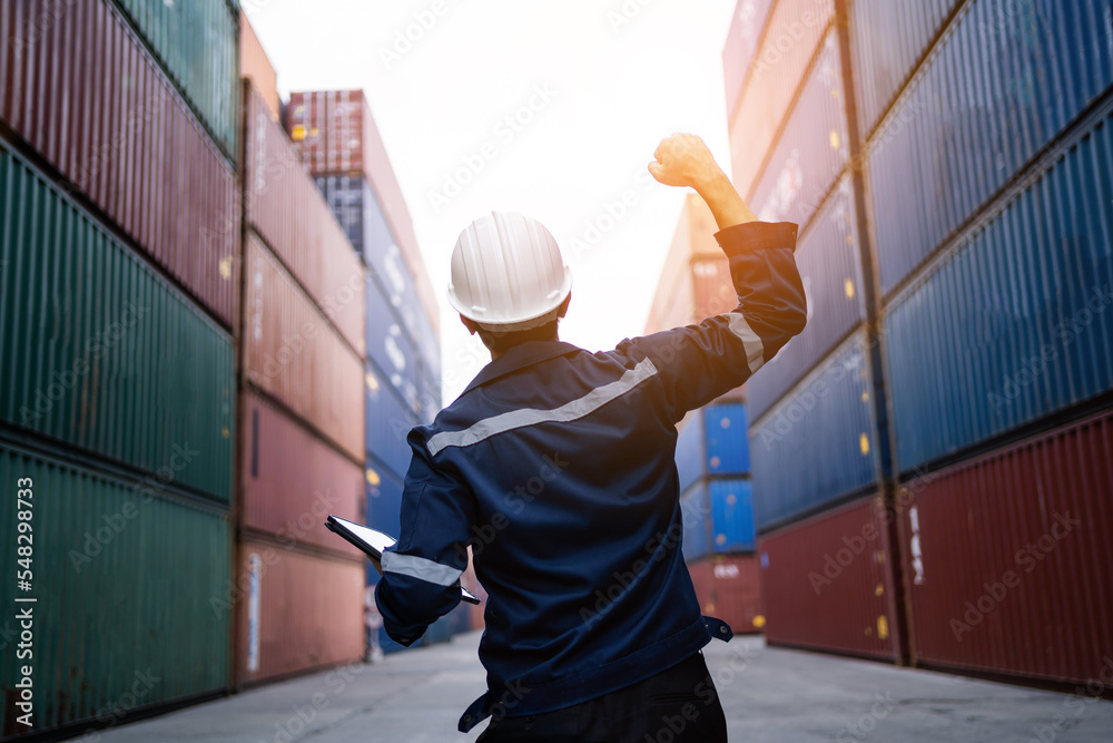 Engineer or foreman controls loading of containers from cargo ship for import export, worker ...