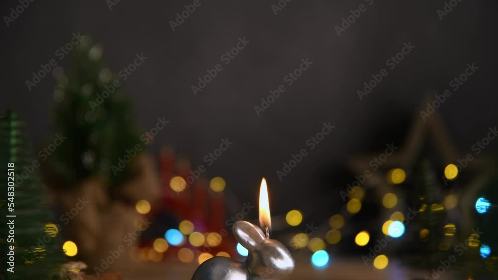 candle in the form of a rabbit symbol of 2023 among the lights ...