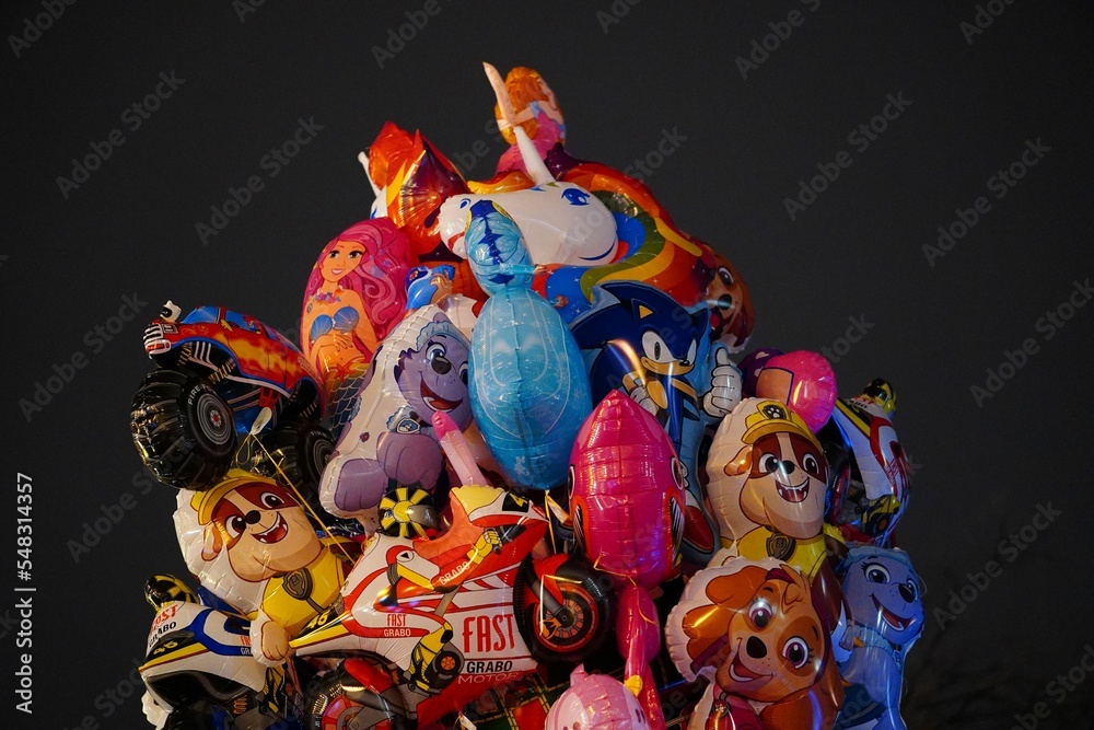 Selective focus of helium balloons with different cartoon characters on ...
