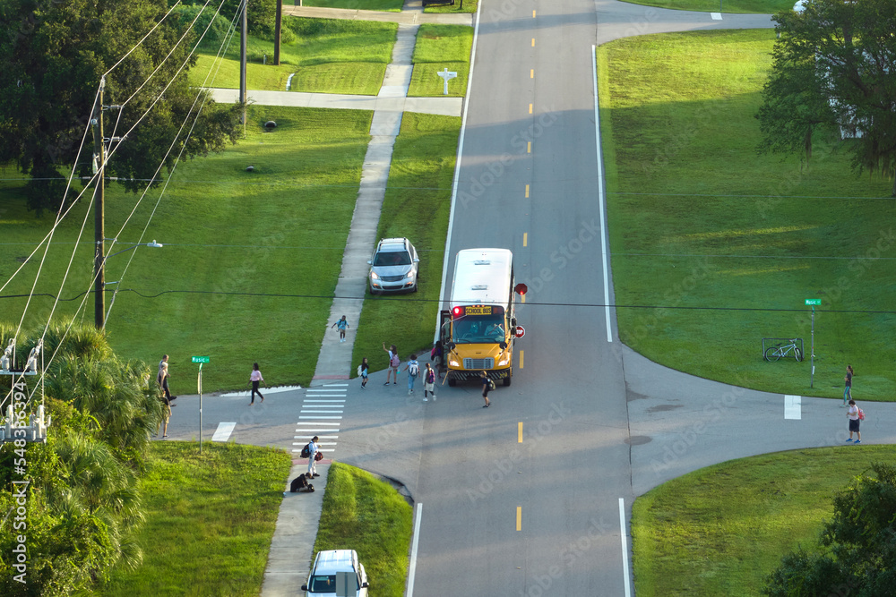 Top view of standard american yellow school bus picking up kids at ...