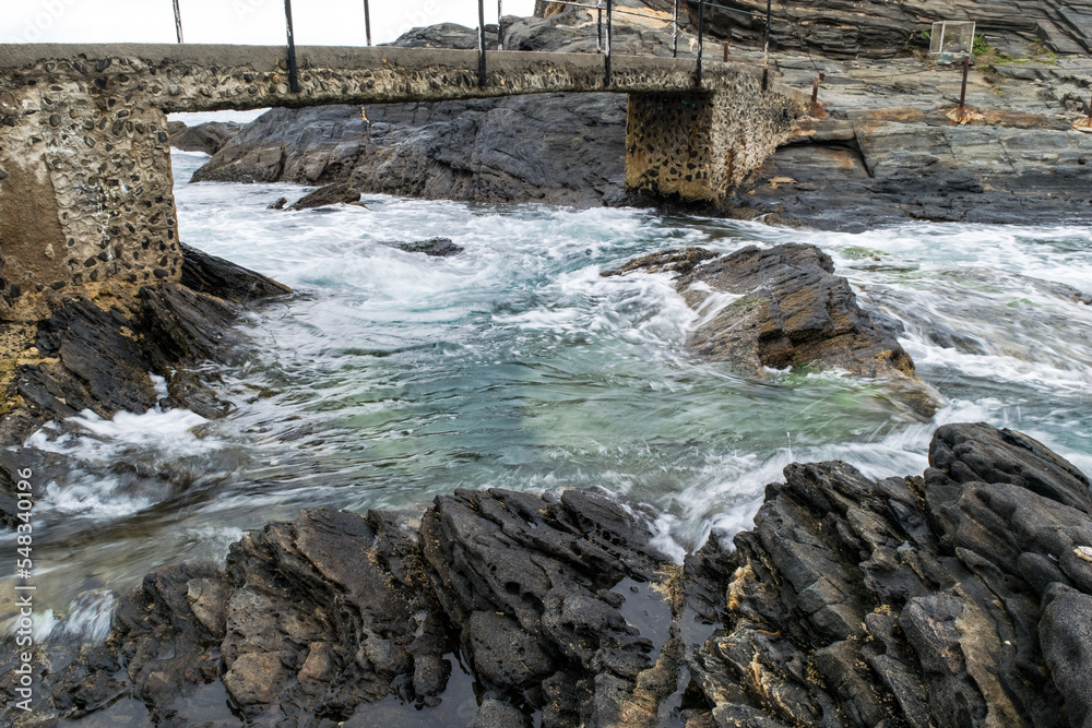 Praias rochassas do forte em volta do Forte São Mateus, com a água azul ...