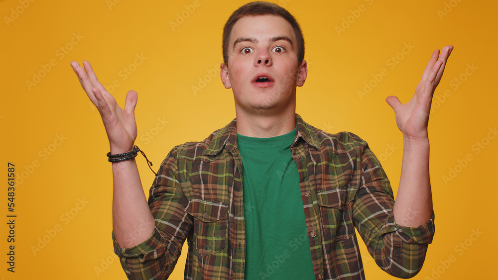 Excited amazed man 20s in shirt touching head and showing explosion ...