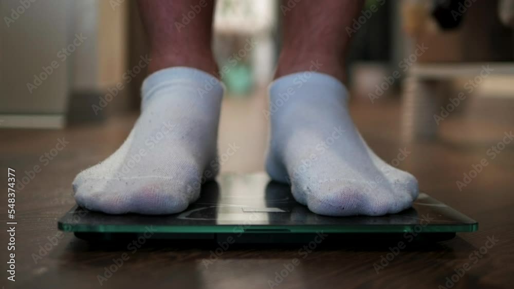 Video Stock Men's feet stand on floor scales. A person is weighed on a ...