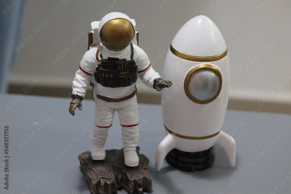 Plaster miniature astronaut and rocket. Astronaut in traditional ...