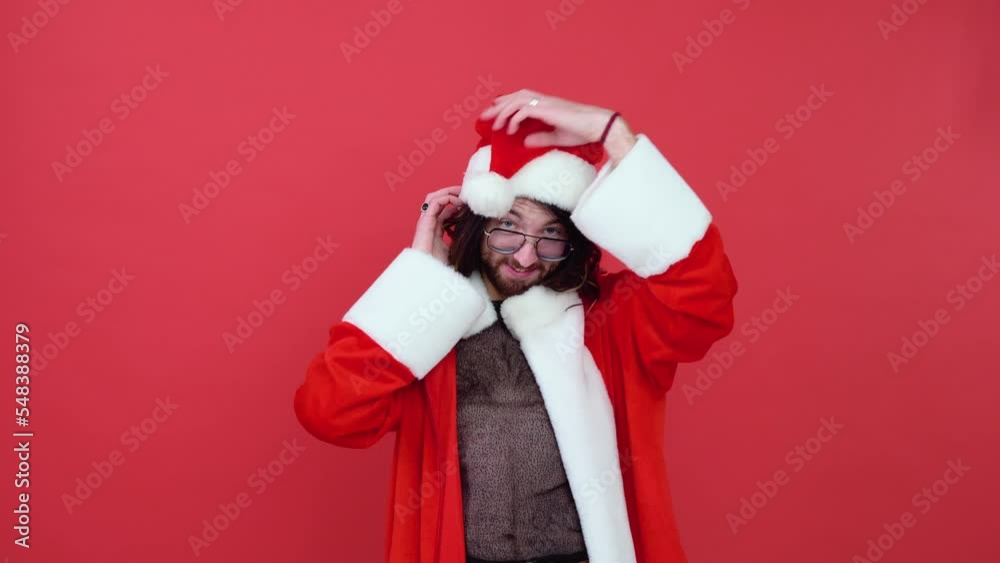 Portrait of a gay man on a red background. Gay in the suit of Santa ...