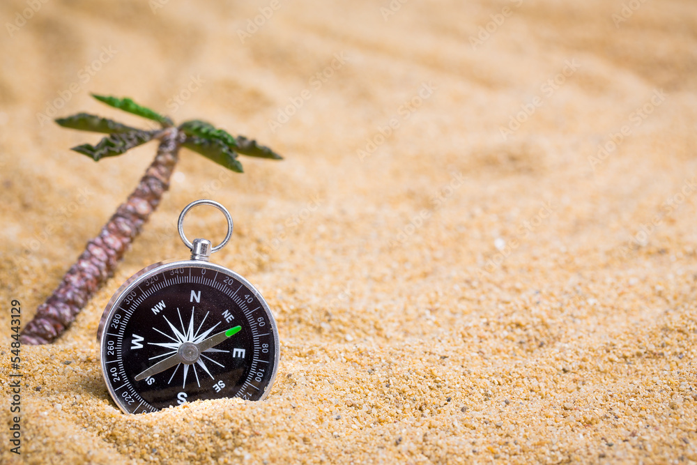 Compass in the sea sand on beach background with copy space for add ...
