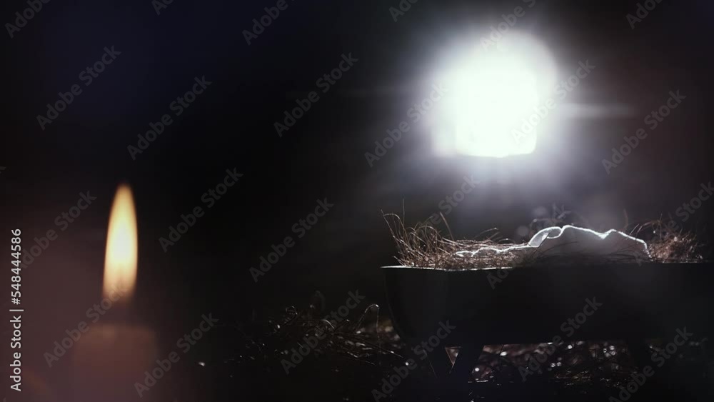 Bright light from the window illuminates the baby Jesus in the manger ...