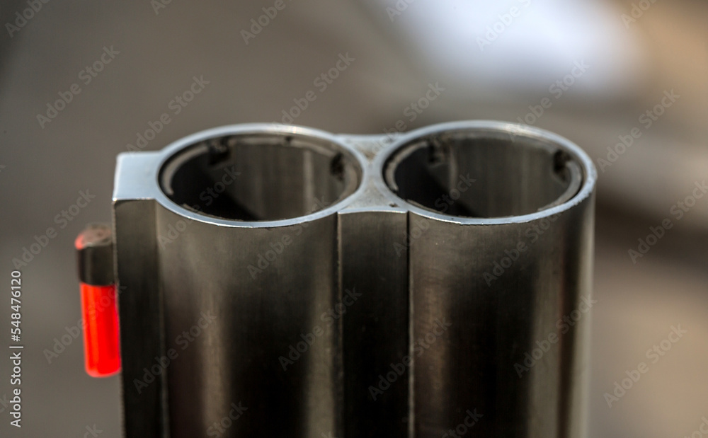 The double-barreled shotgun is on a stand. The barrel of a weapon close ...