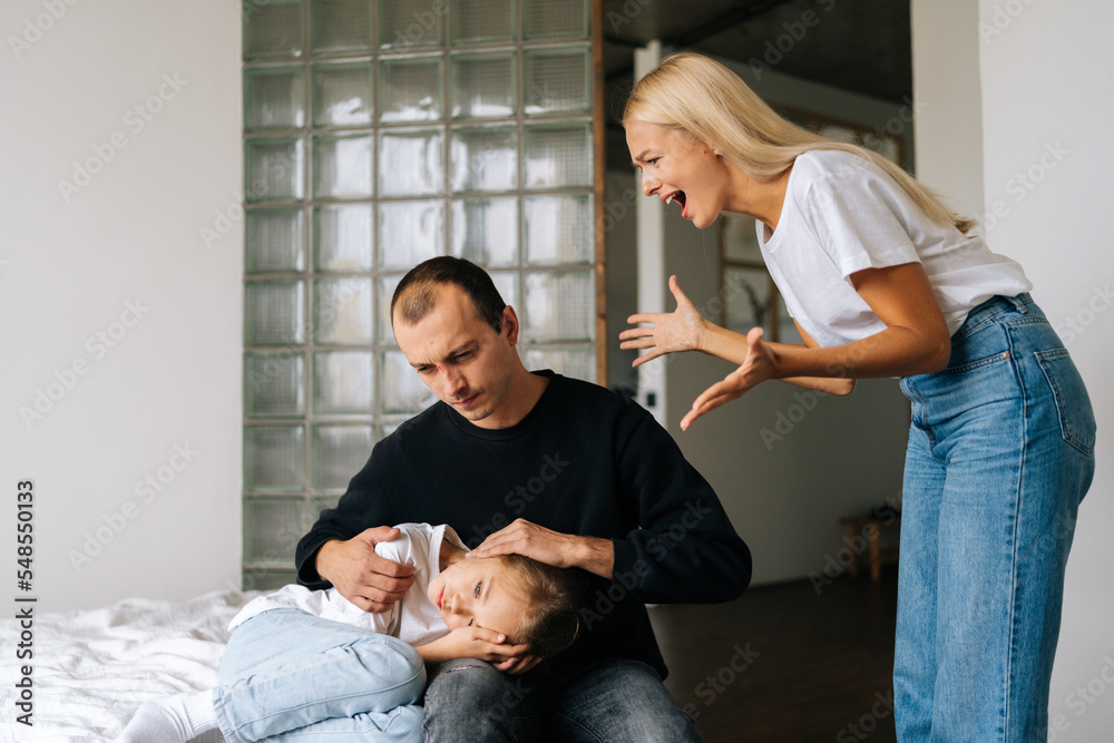 Portrait of scared tired father and daughter hugging each other sitting ...