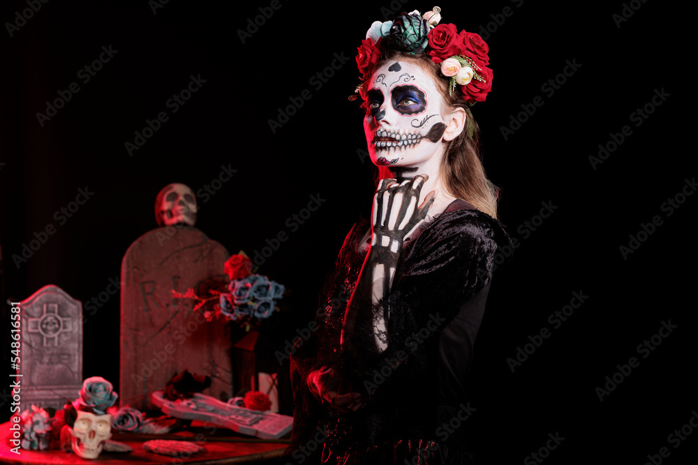 Spooky lady of death wearing black skull costume in studio, looking ...