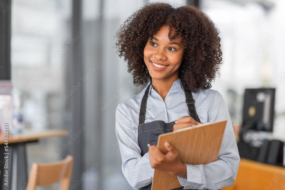 Female African coffee shop small business owner wearing apron standing ...