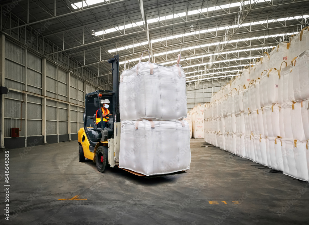 Forklift stack jumbo bags of sugar, rice, grain inside a warehouse ...