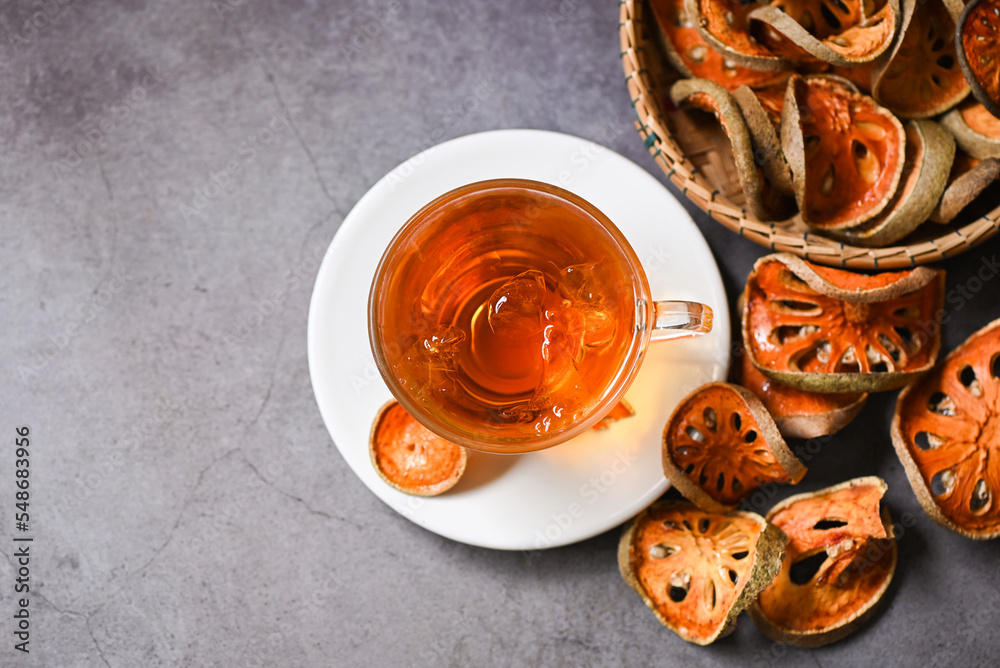 Bael tea on glass with dried bael slices on dark background, Bael juice ...