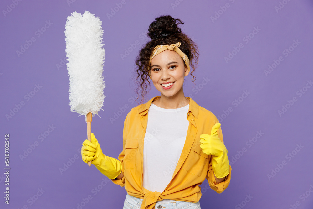 Young happy housekeeper woman wear yellow shirt rubber gloves hold ...
