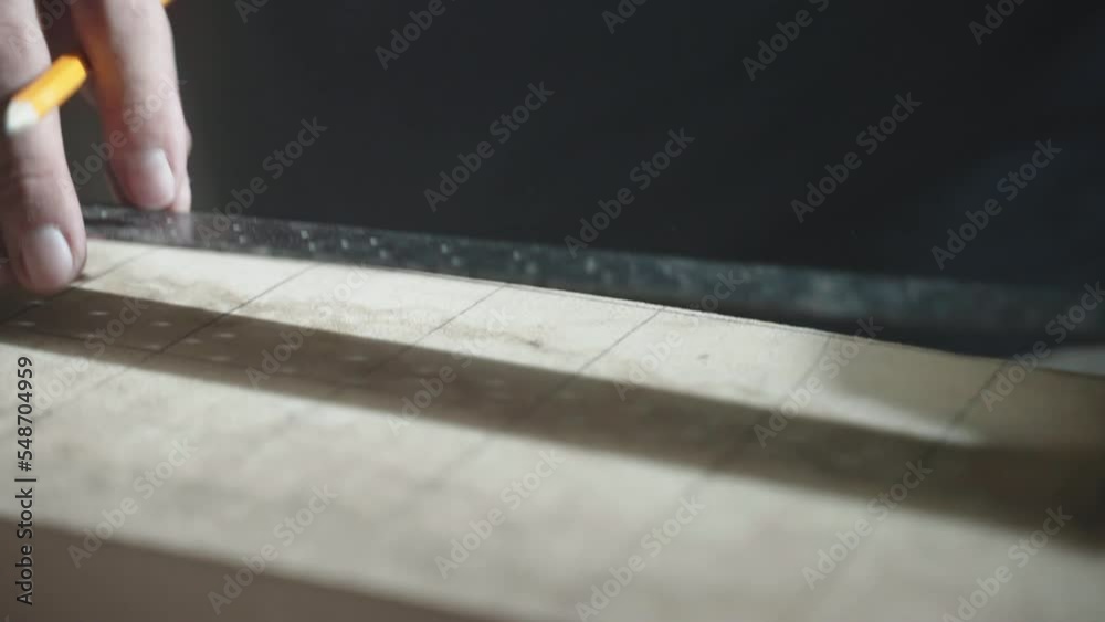Professional carpenter using pencil and metal ruler for making ...