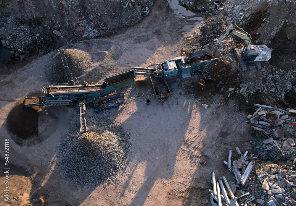 Recycling concrete and asphalt from demolition. Excavator at landfill ...