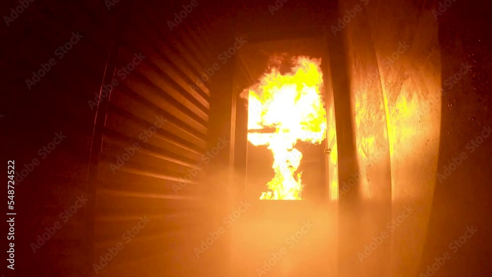 Slow motion, POV, of flashover during firefighter training inside a ...