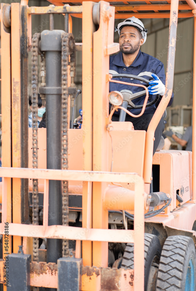 Male foreman is driving heavy lifting forklift at shipping container ...