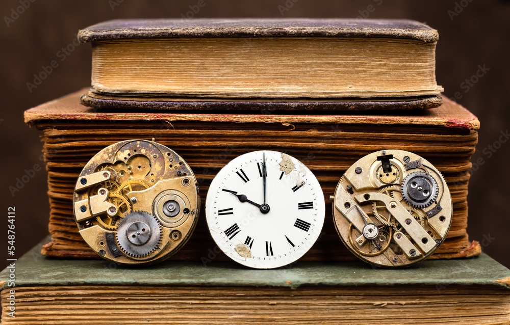 Old vintage books with antique clock and clockworks. Knowledge ...