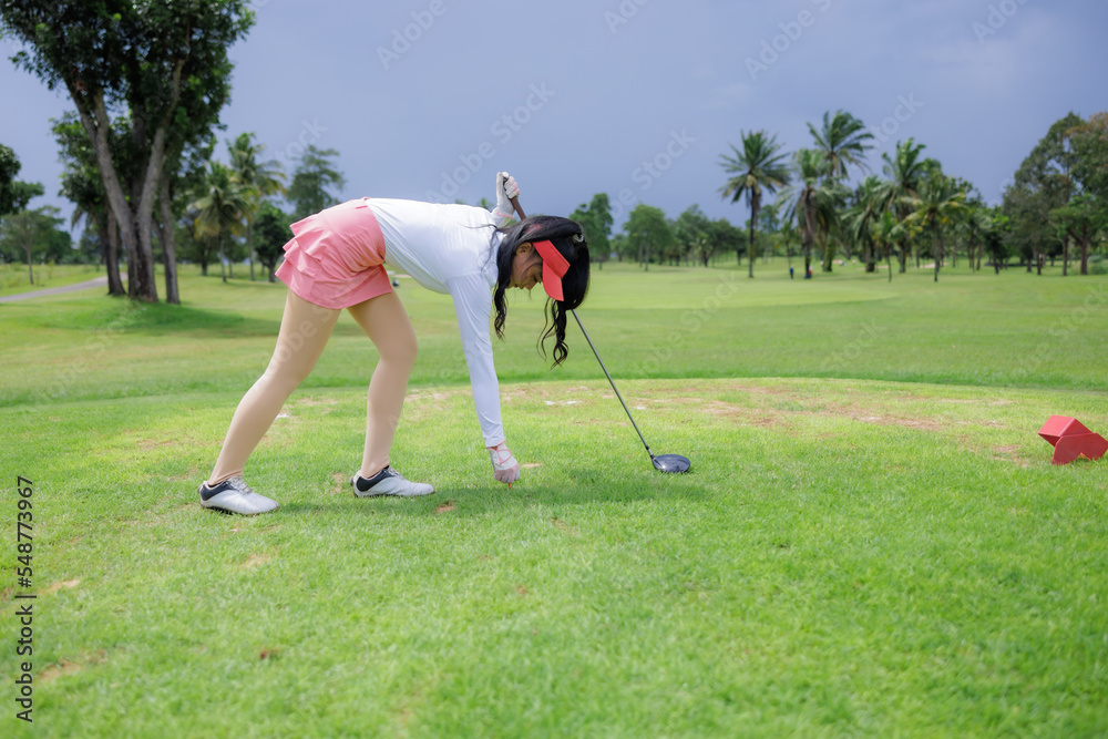 female asian profesional golfer hold golf ball put on tee by glove golf ...