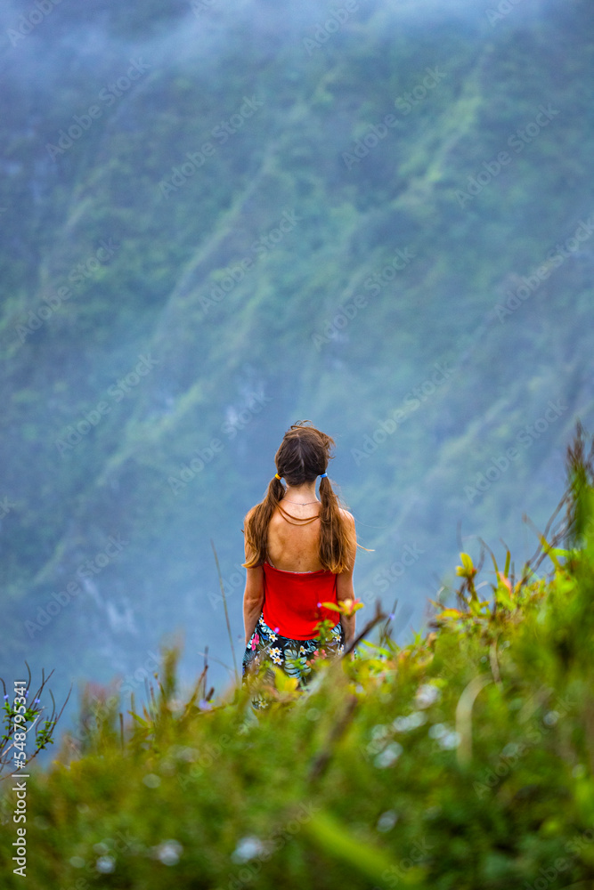 girl in pigtails stands at the top of the kuliouou ridge trail admiring ...