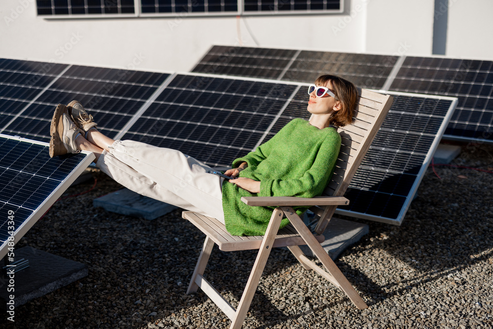 Foto de Young woman sits relaxed on a lounge chair while resting on ...