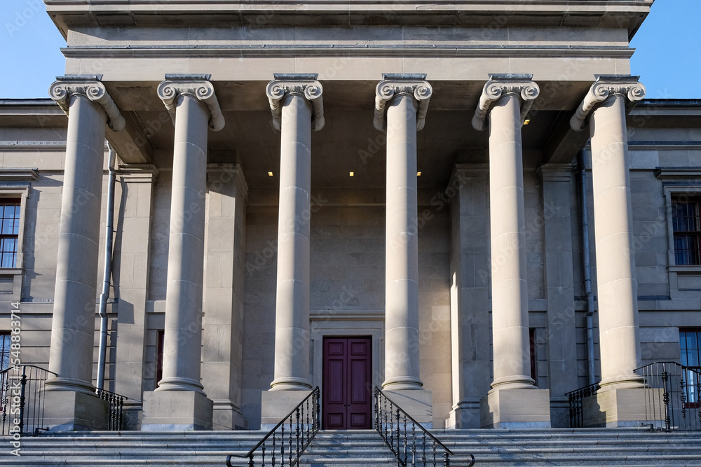 Four large round concrete columns at the top of marble steps with black ...