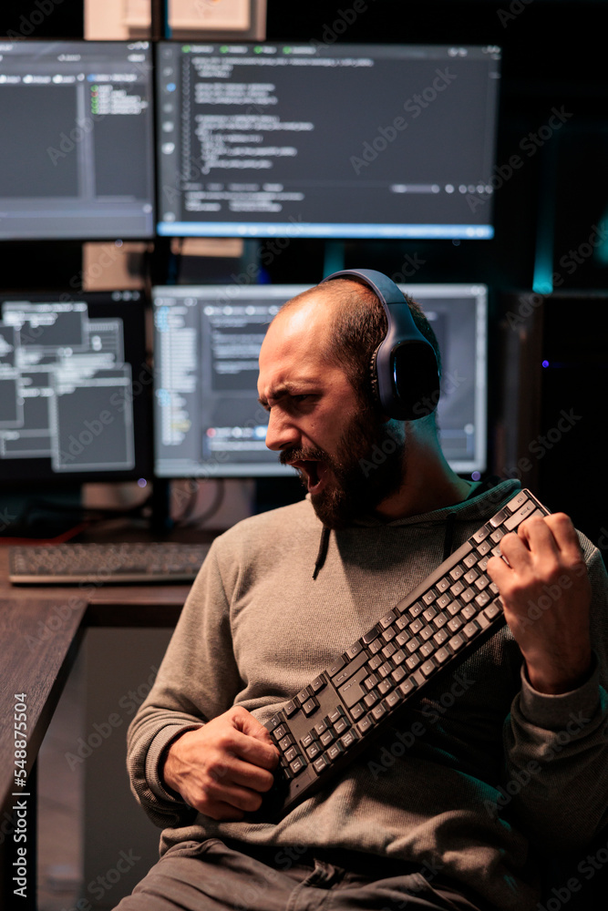 Funky developer singing at air guitar keyboard late at night, working on cloud computing html ...