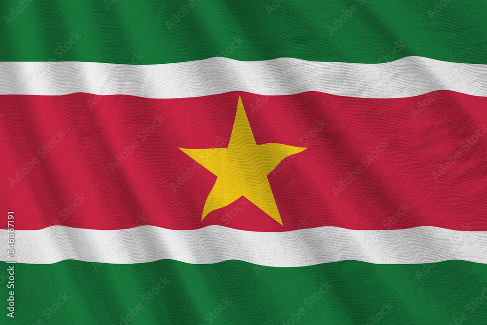 Suriname flag with big folds waving close up under the studio light ...