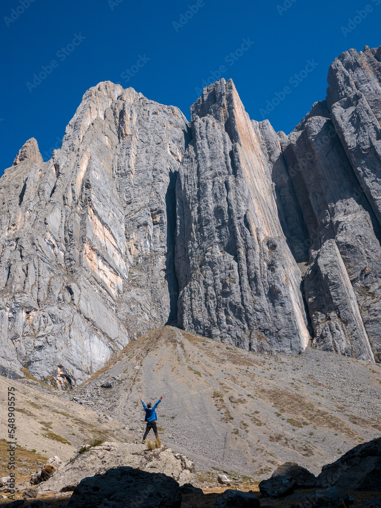 Hombre levantando las manos hacia una gran montaña de rocas con el ...