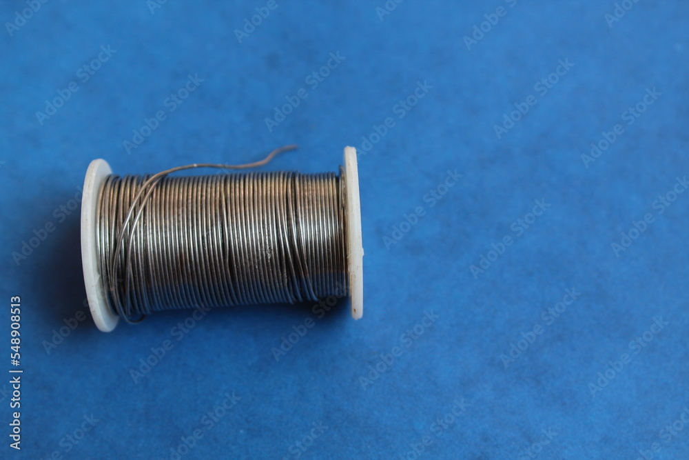 Soldering wire on a plane background used to solder elctronic ...