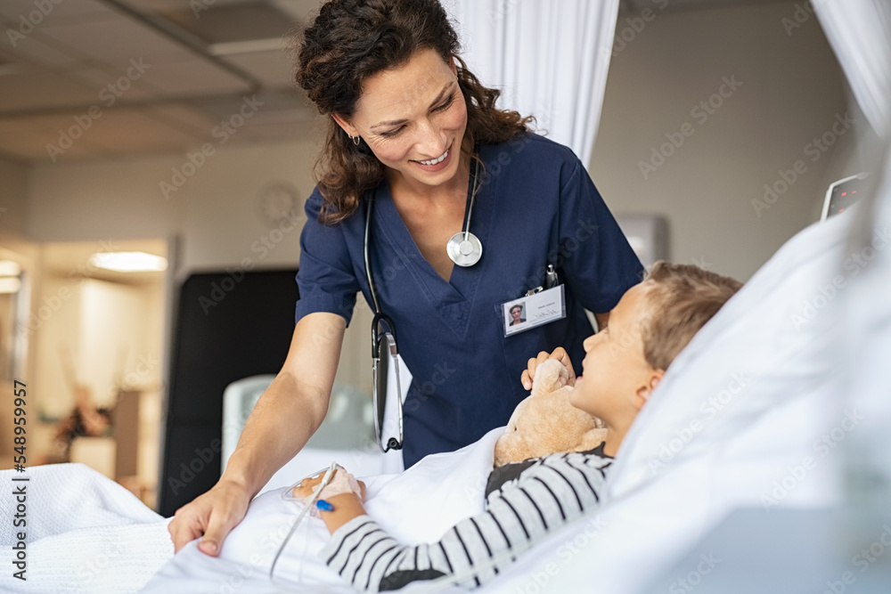 Foto de Lovely nurse take care of child at clinic do Stock | Adobe Stock