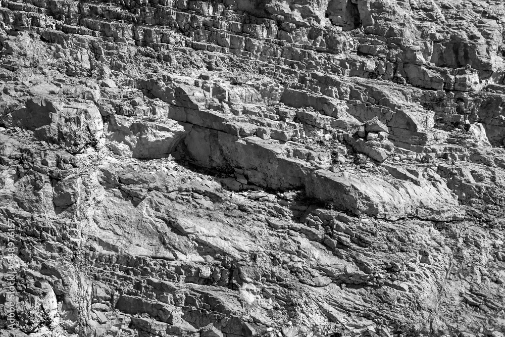 Grungy cragged bumpy pitted cavity stone facade, split layer gap.Ruined ...