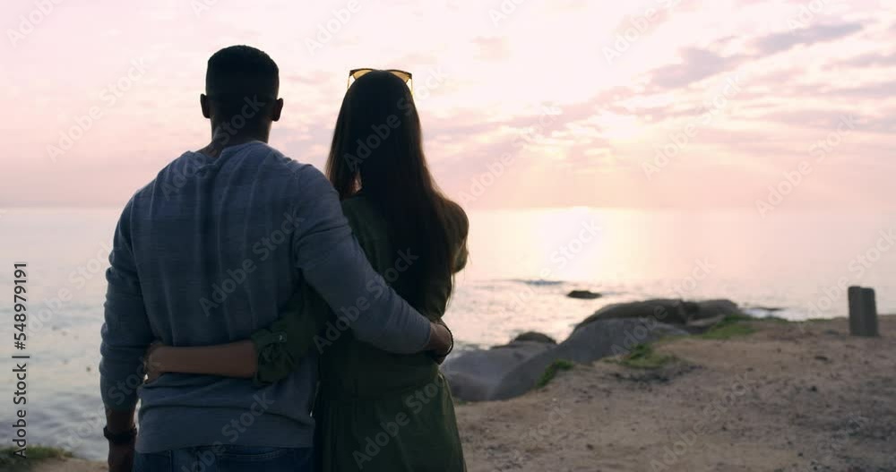 Love, sunset and back view of couple at beach, hugging and embrace ...