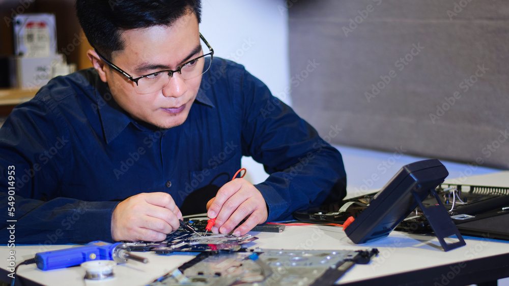 Young man wearing glasses who is a computer technician A laptop ...