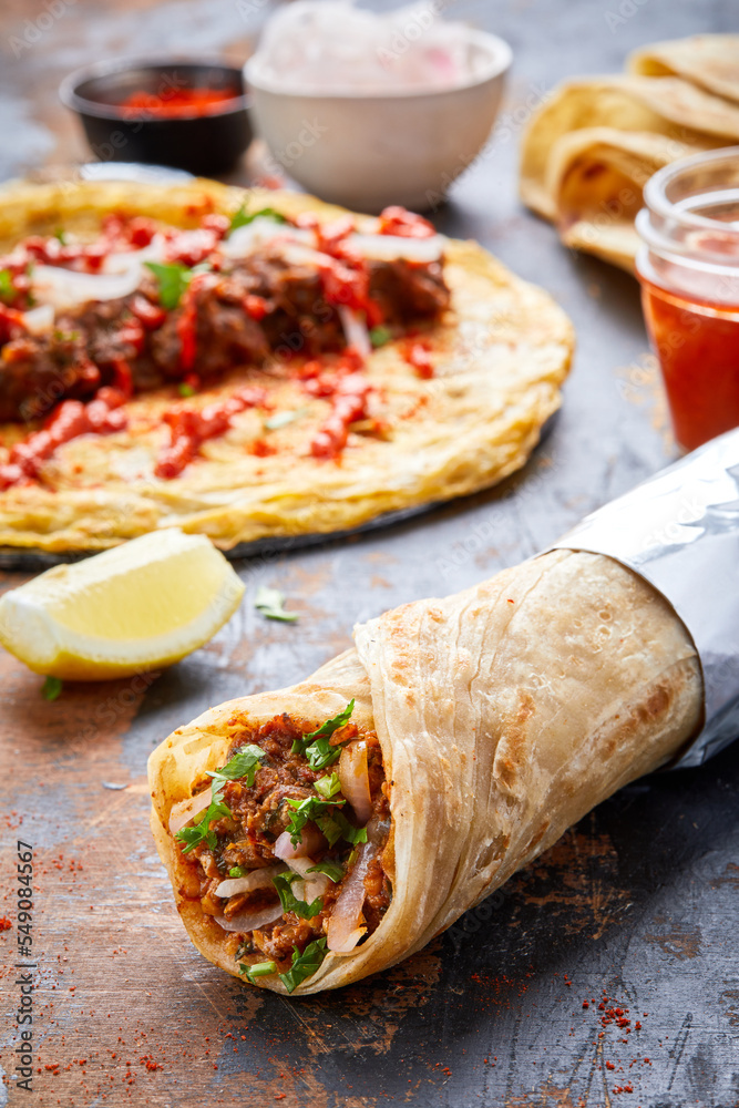 Beef Bhuna paratha roll kathi shawarma wrap with dipping sauce isolated ...