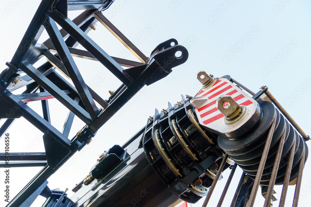 The boom of a wheeled crane and a rope for lifting loads in close-up ...
