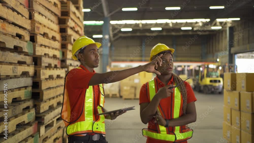 Team of a couple of black worker working in large warehouse retail ...