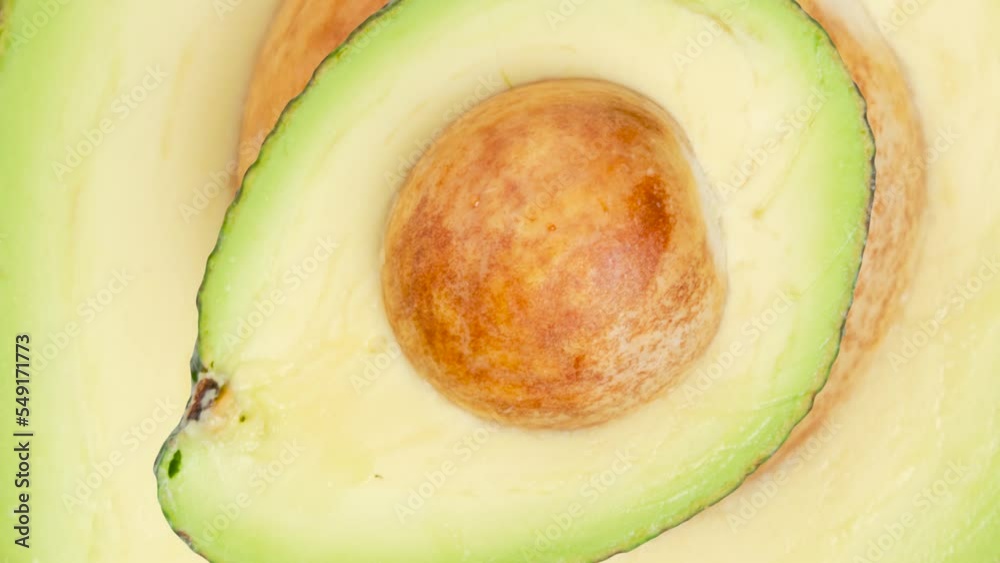 Zooming half of Avocado with seed in seamless loop background. Exotic ...