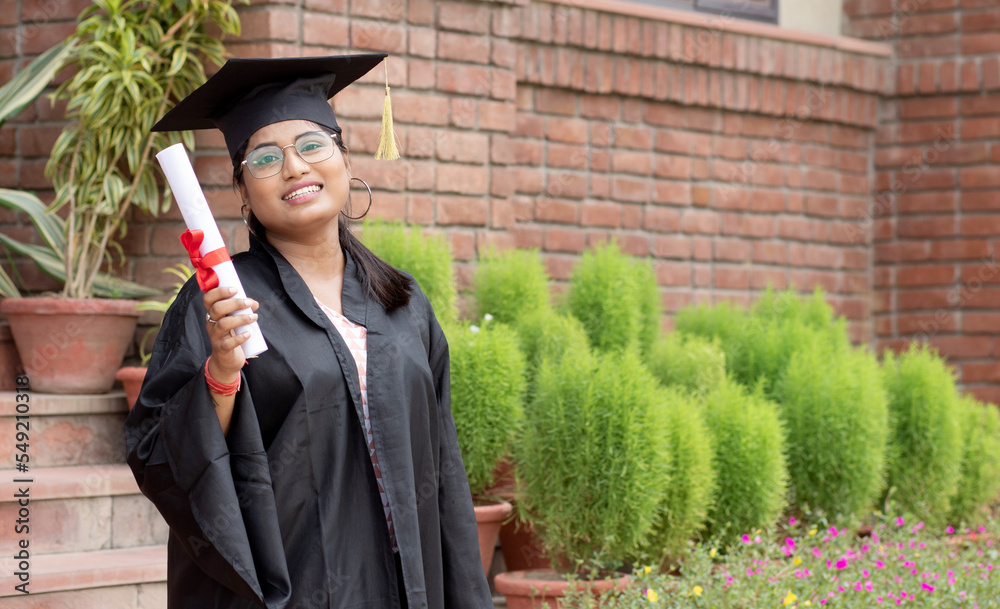 Young indian graduated girl holding graduation degree convocation ...