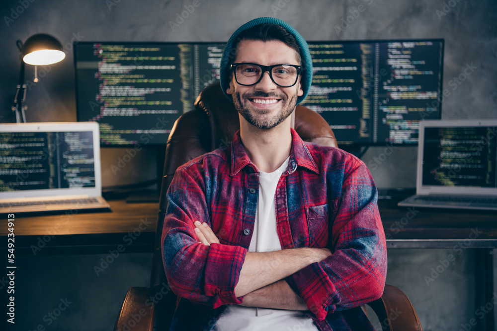Photo of good mood happy coder dressed hat glasses smiling arms folded indoors workplace ...