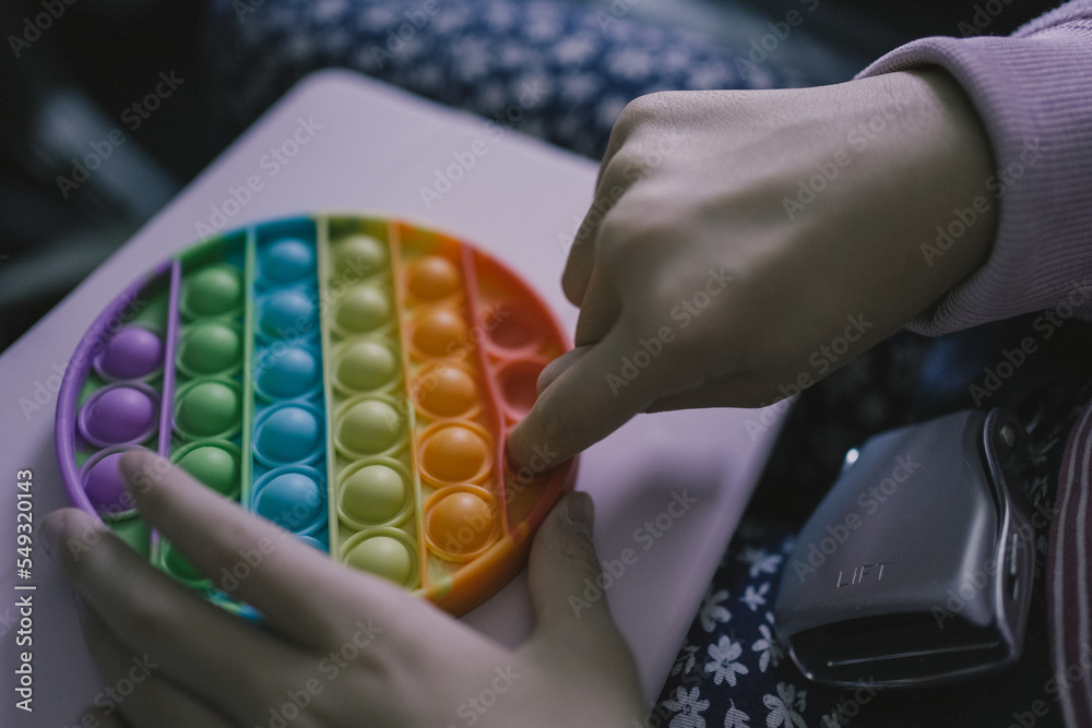 child girl playing with pop it, fidget toy on an airplane,family ...