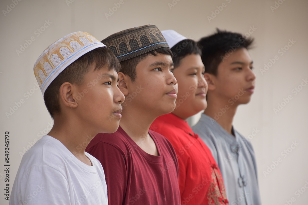 Young asian muslim or islamic boys standing in a row in front of white ...