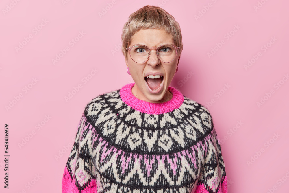 Outraged furious woman with short fair hair shouts loudly with opened ...