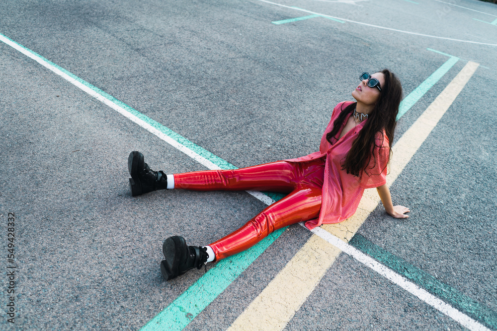Young model sitting on a basketball field floor posing for glam ...