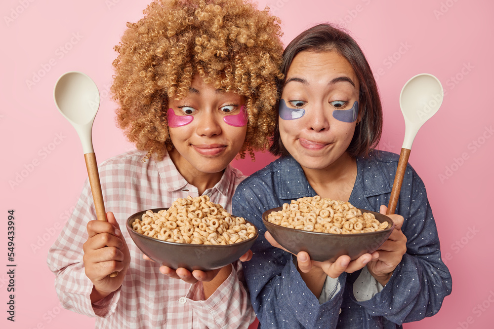 Photo of surprised beautiful women stare at appetizing cereals feel ...